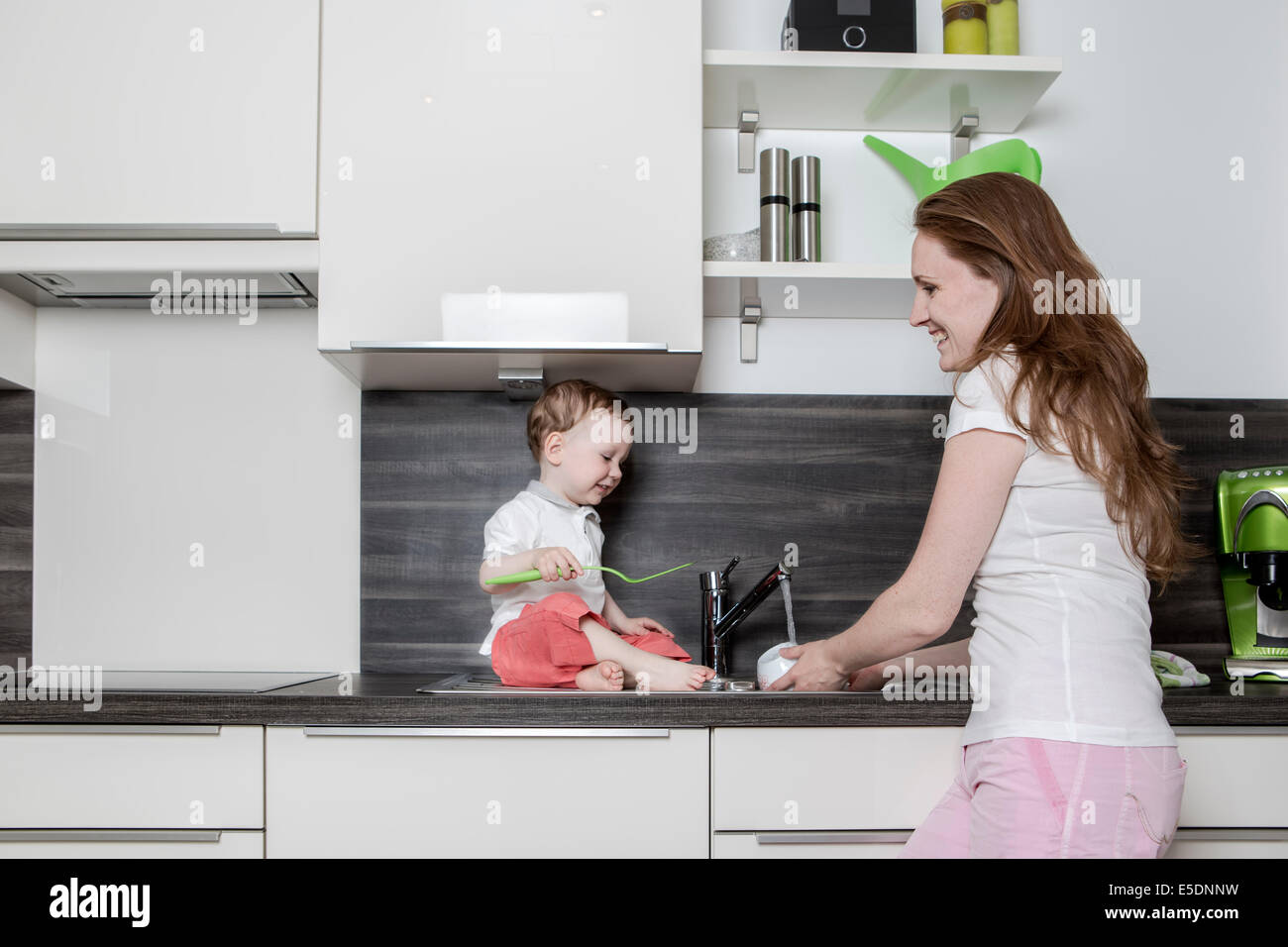 Mother with baby boy in kitchen Stock Photo - Alamy
