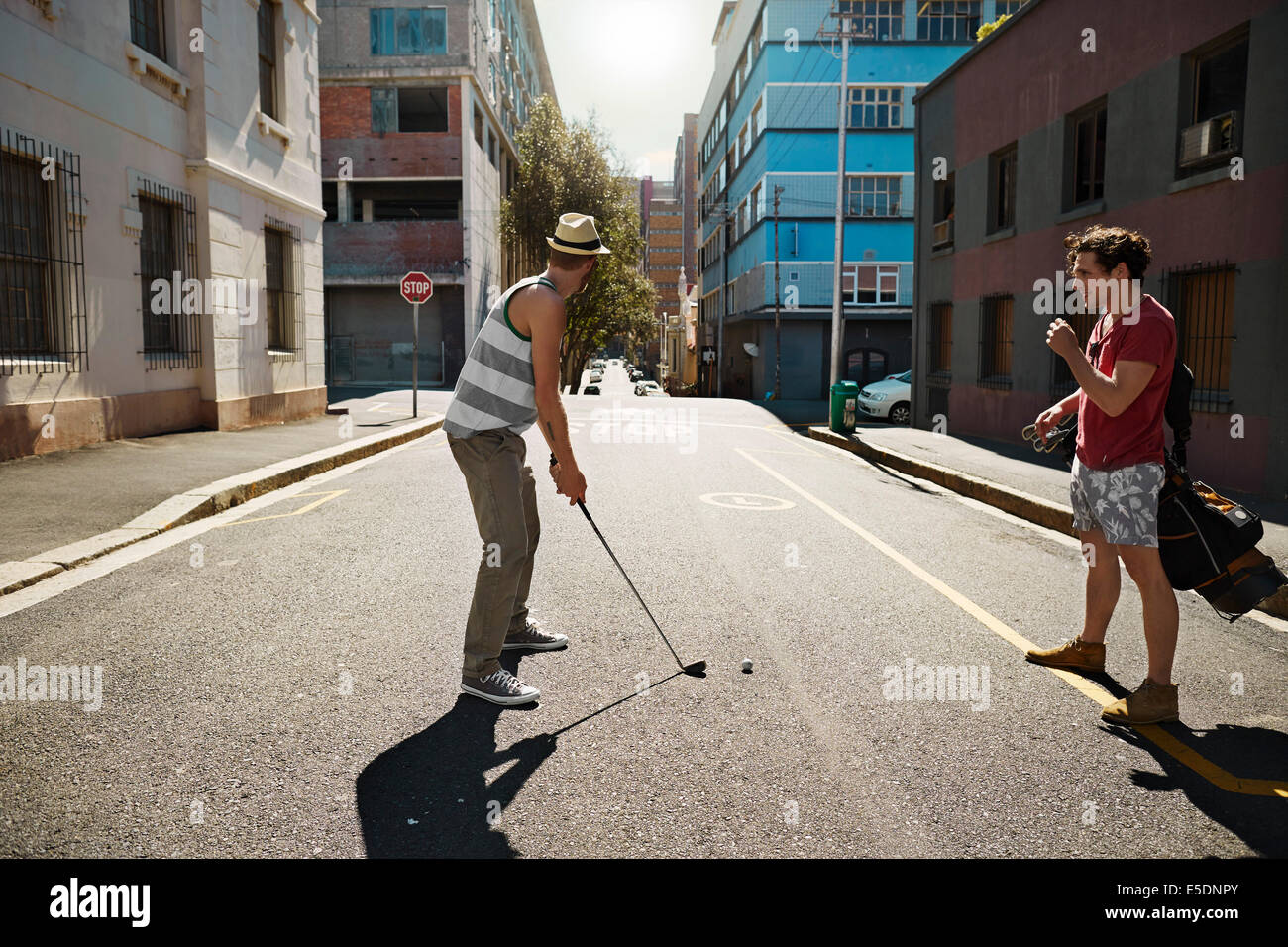 Two friends playing urban golf in the city Stock Photo - Alamy