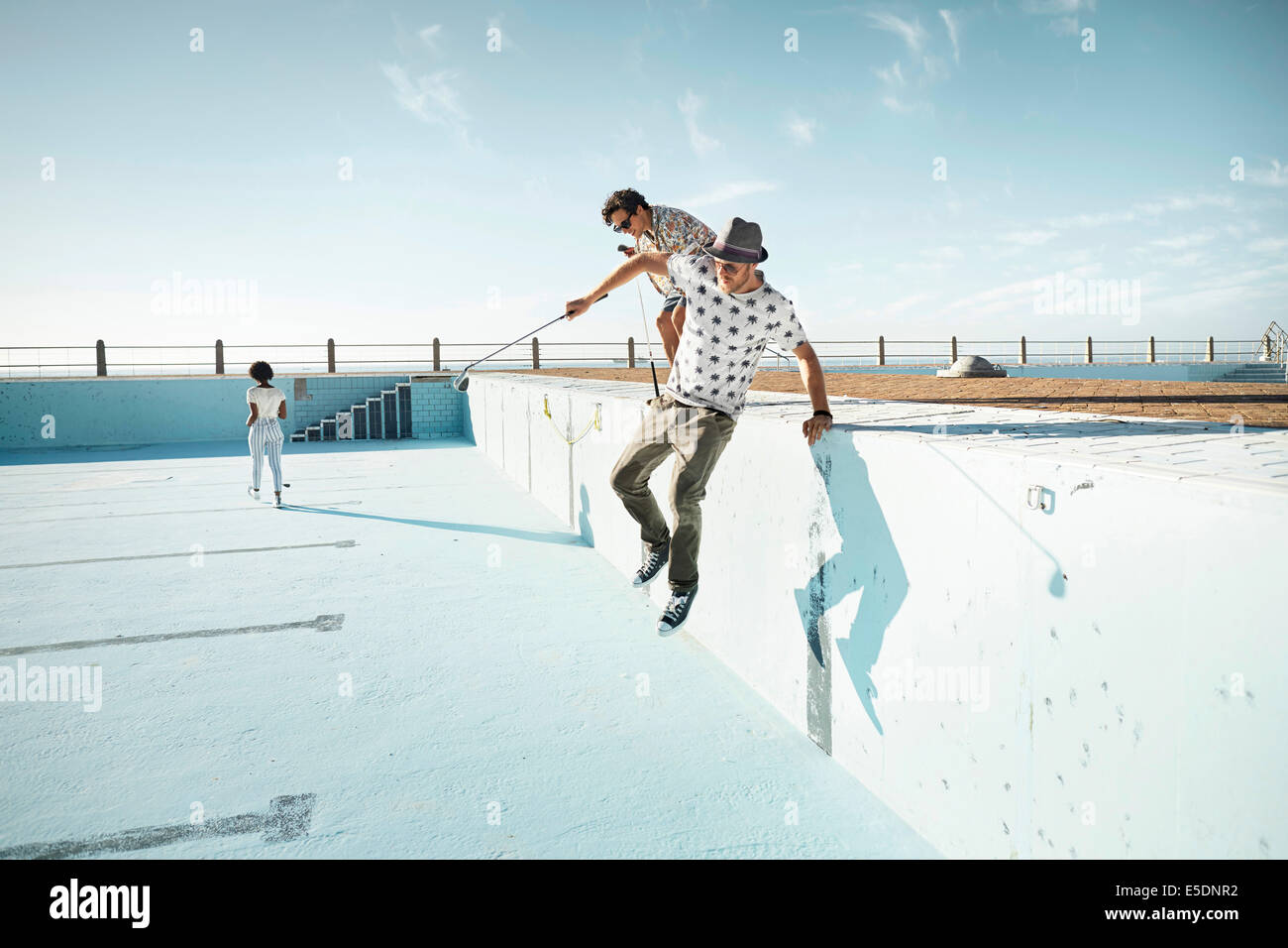 Friends playing urban golf in empty swimming pool Stock Photo - Alamy