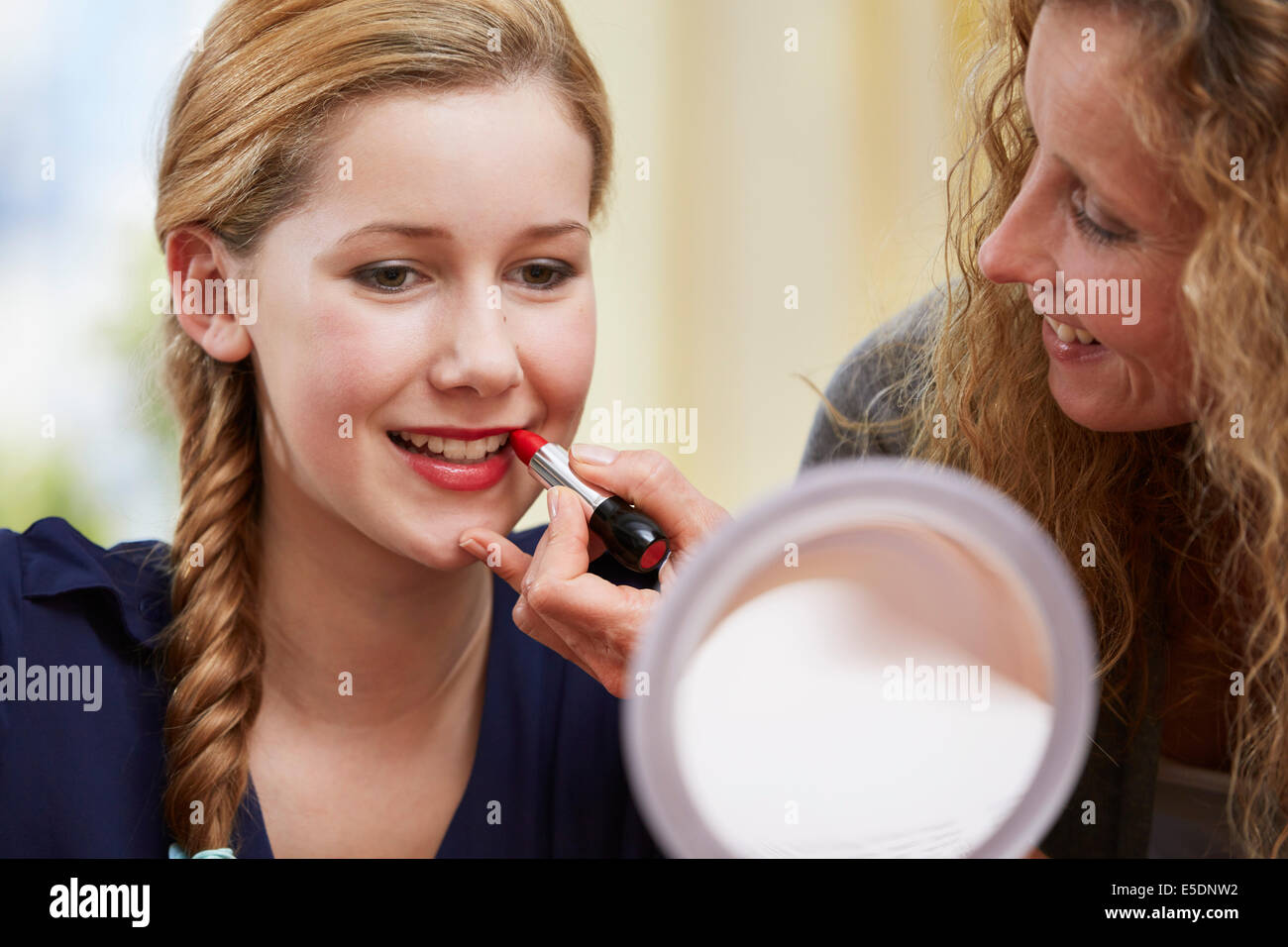 Mother showing her daughter how to use lipstick Stock Photo - Alamy