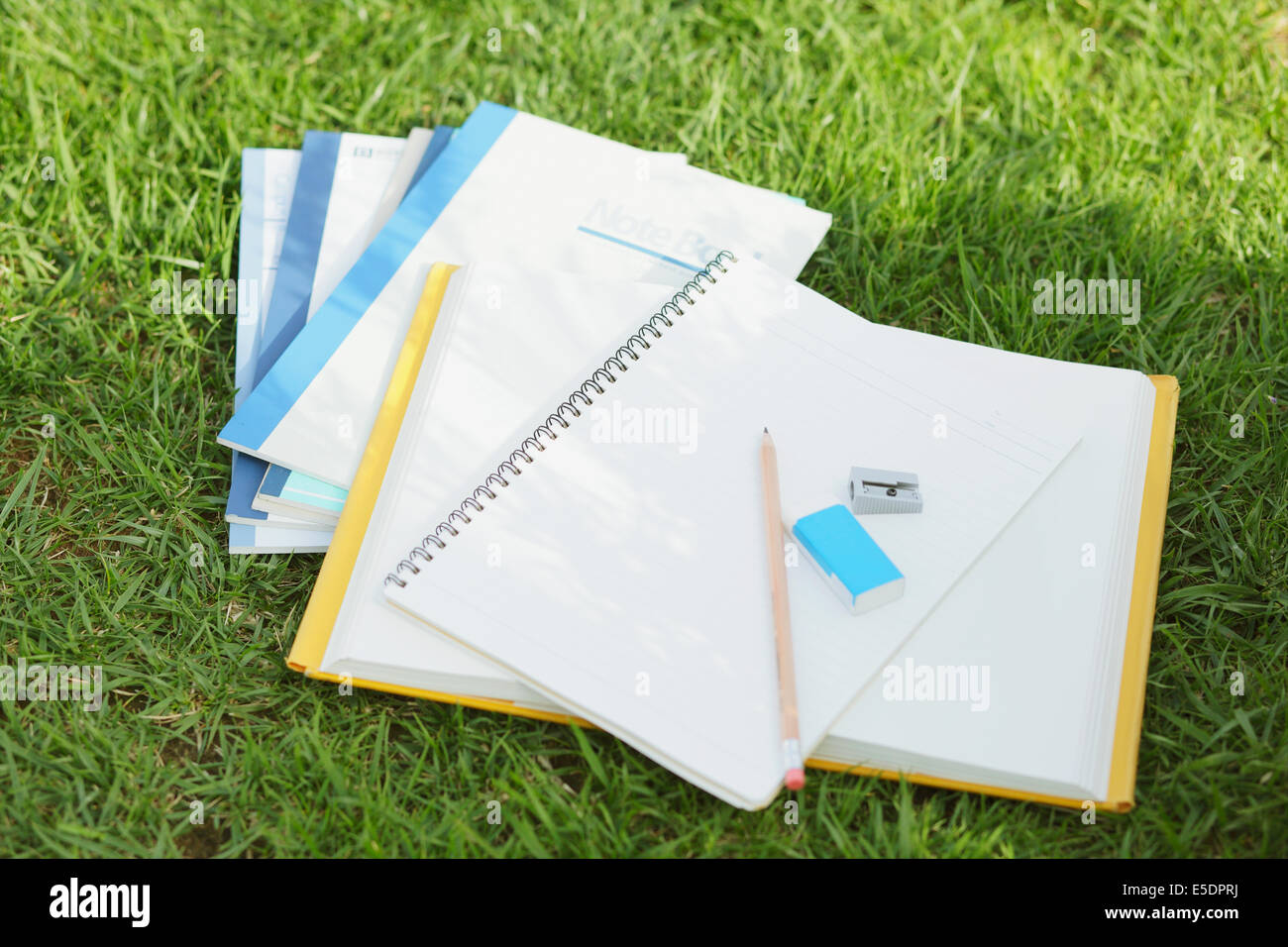 Pencil and notebooks on grass Stock Photo - Alamy