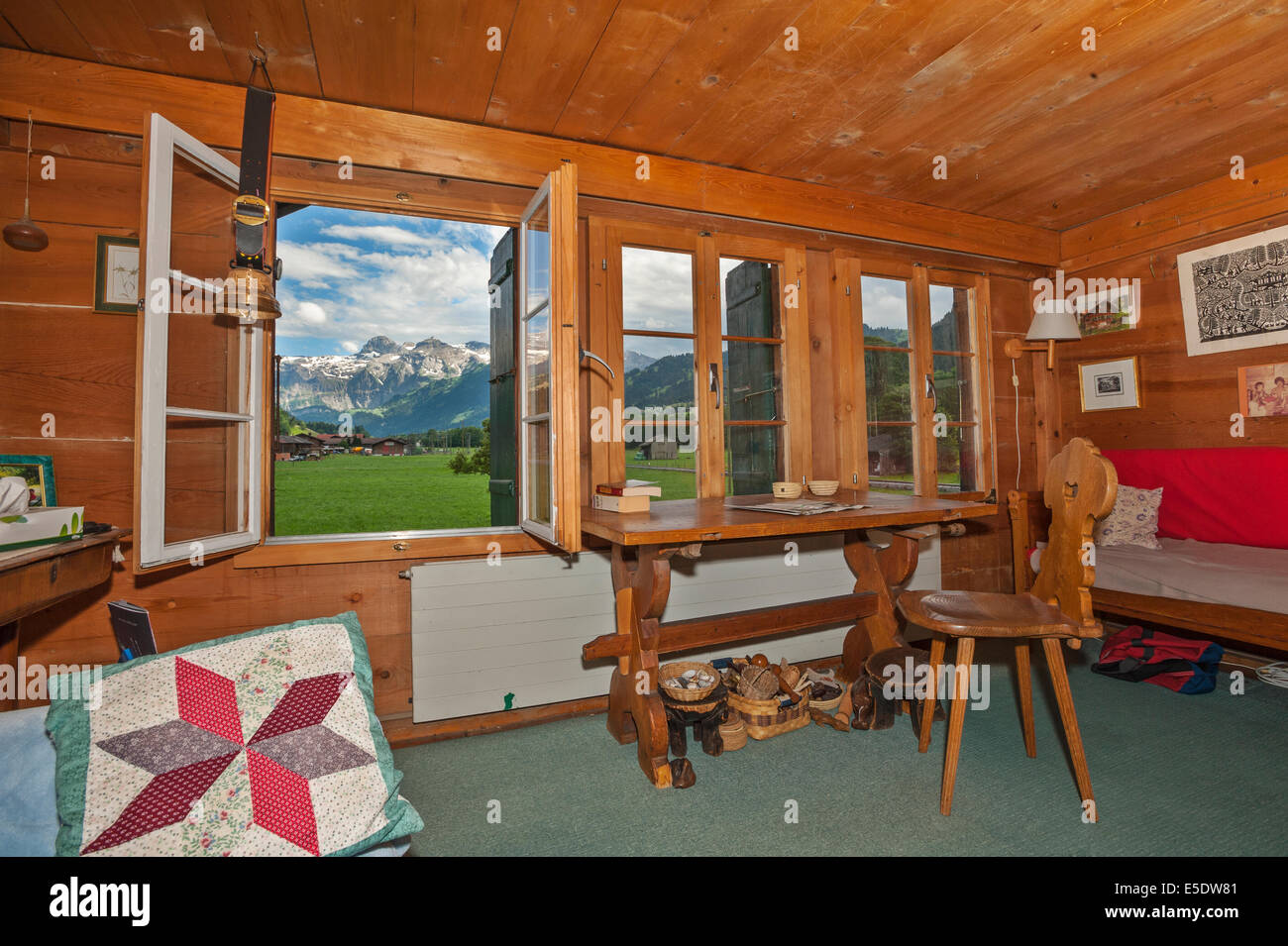 The living room of a traditional Swiss farmhouse, windows open with a ...