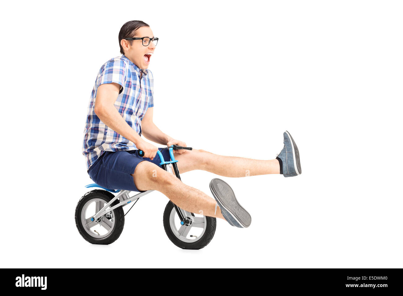 Carefree young guy riding a small bike Stock Photo - Alamy