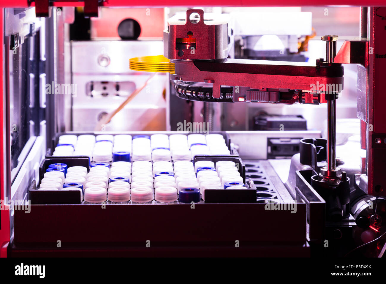 HPLC autosampler in a real laboratory lit with red gel, vials in rack ...