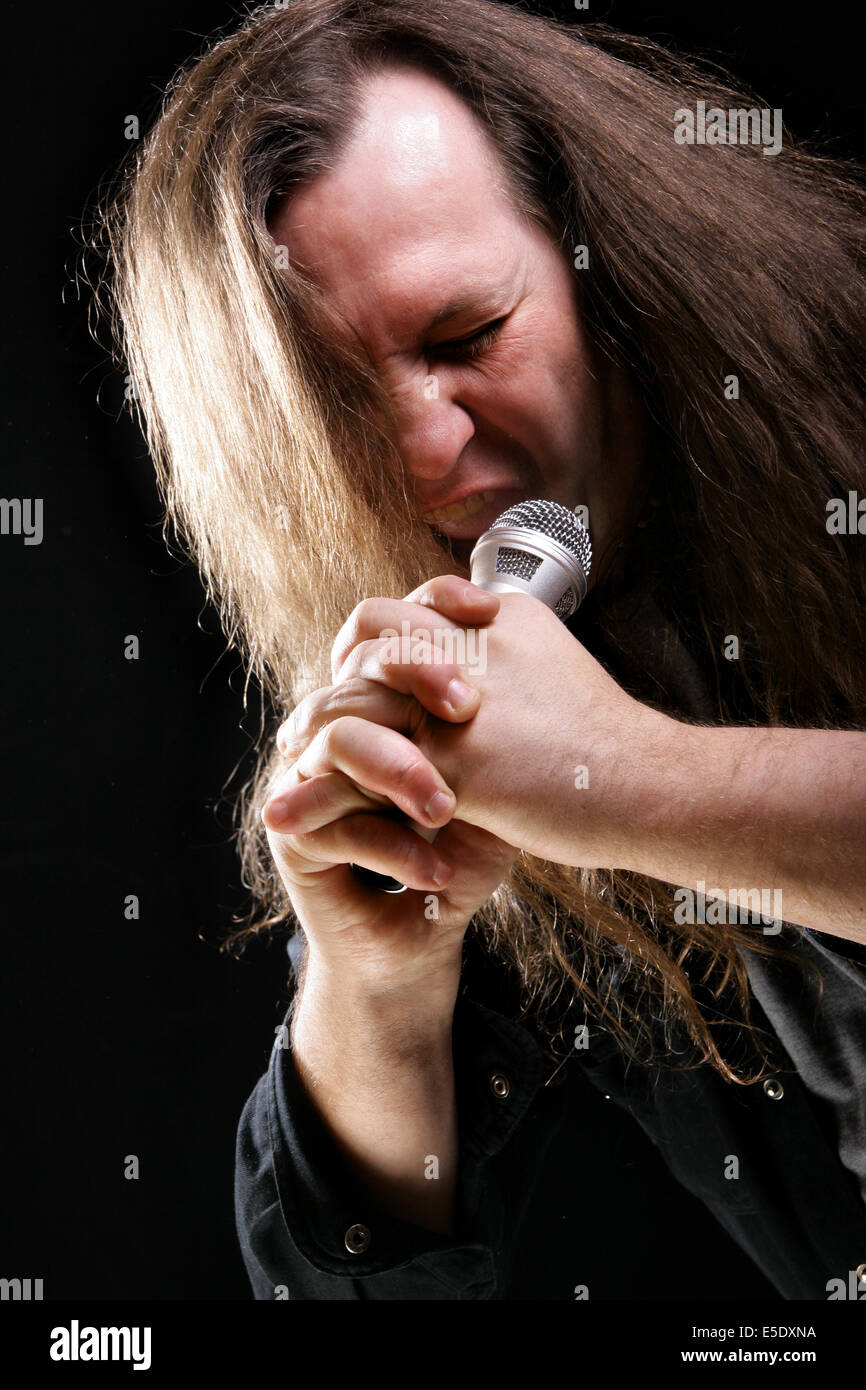 Singer with microphone over black background Stock Photo - Alamy