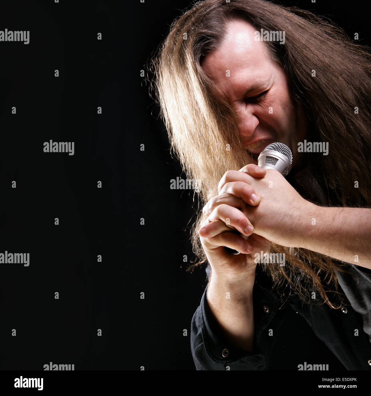 Singer with microphone over black background Stock Photo - Alamy