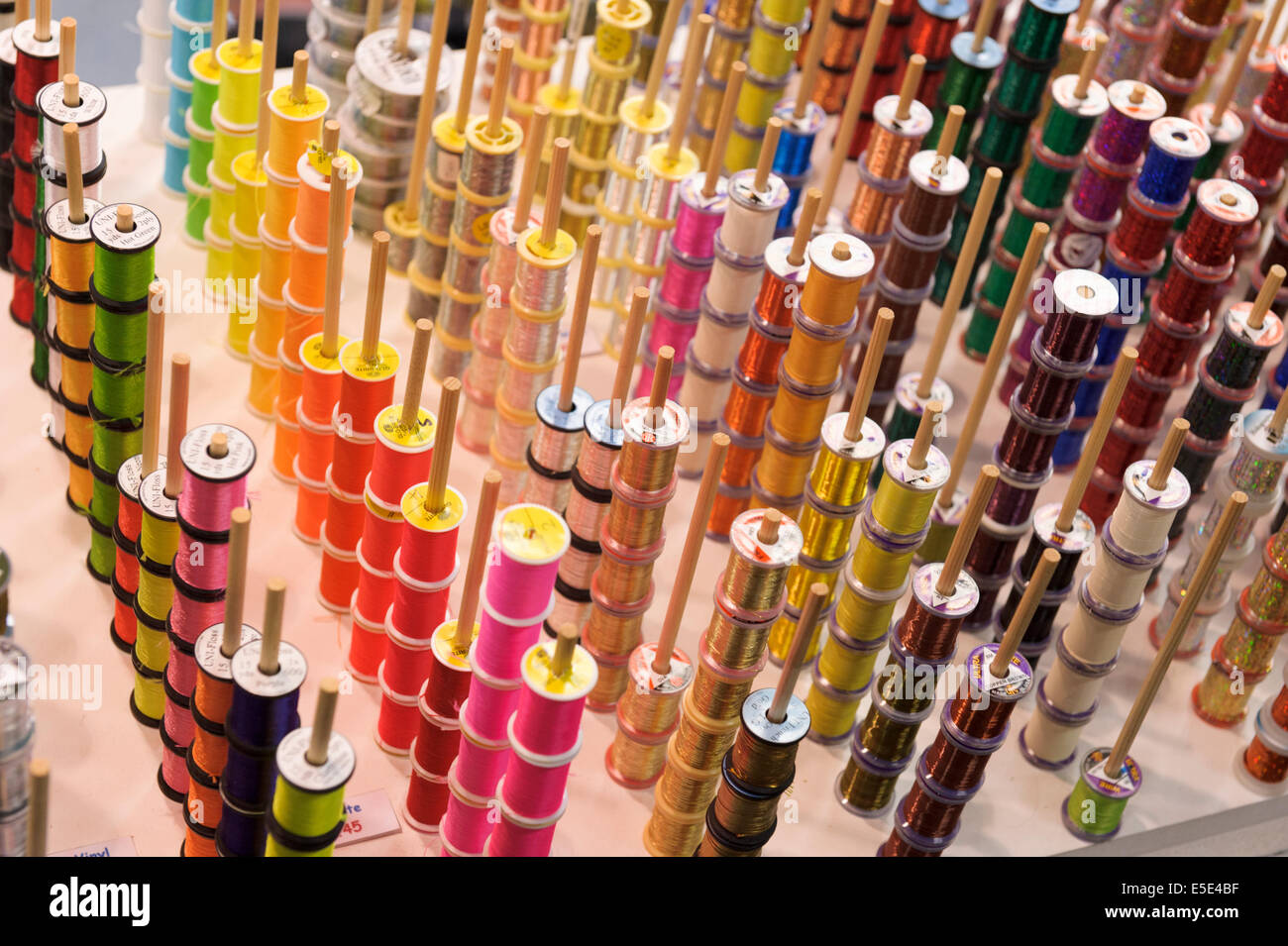 Brightly coloured silk fly-tying thread on display at a fly fair Stock ...