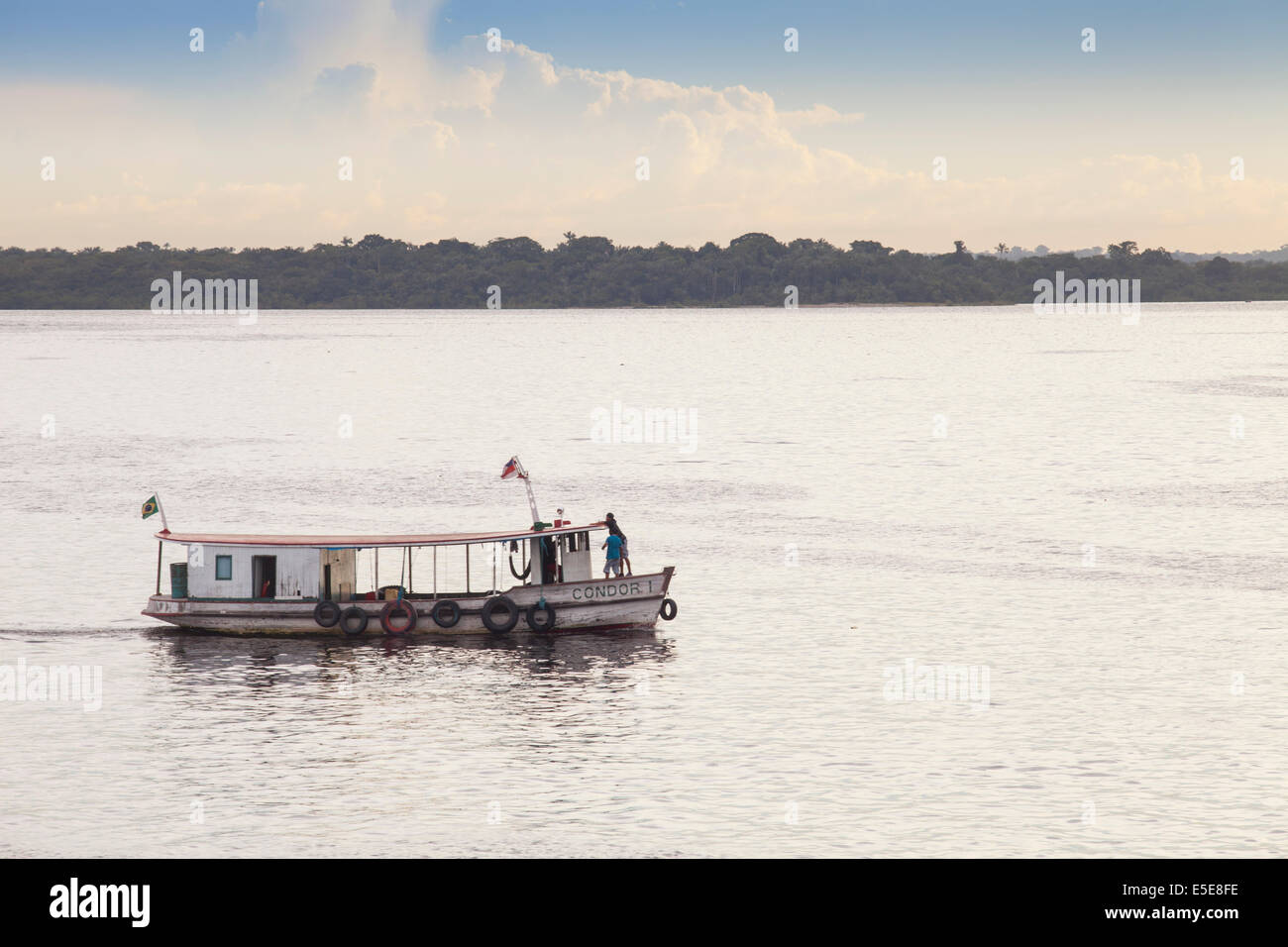 A traditional Amazon wooden river boat on a pristine Amazonian river ...