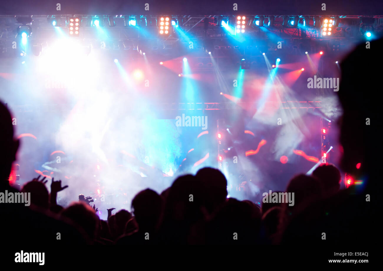 Cheering crowd in front of bright colorful stage lights Stock Photo - Alamy