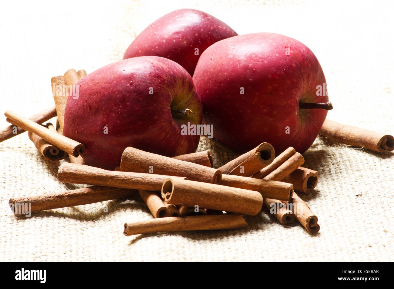 Red apples and cinnamon sticks on white background Stock Photo - Alamy