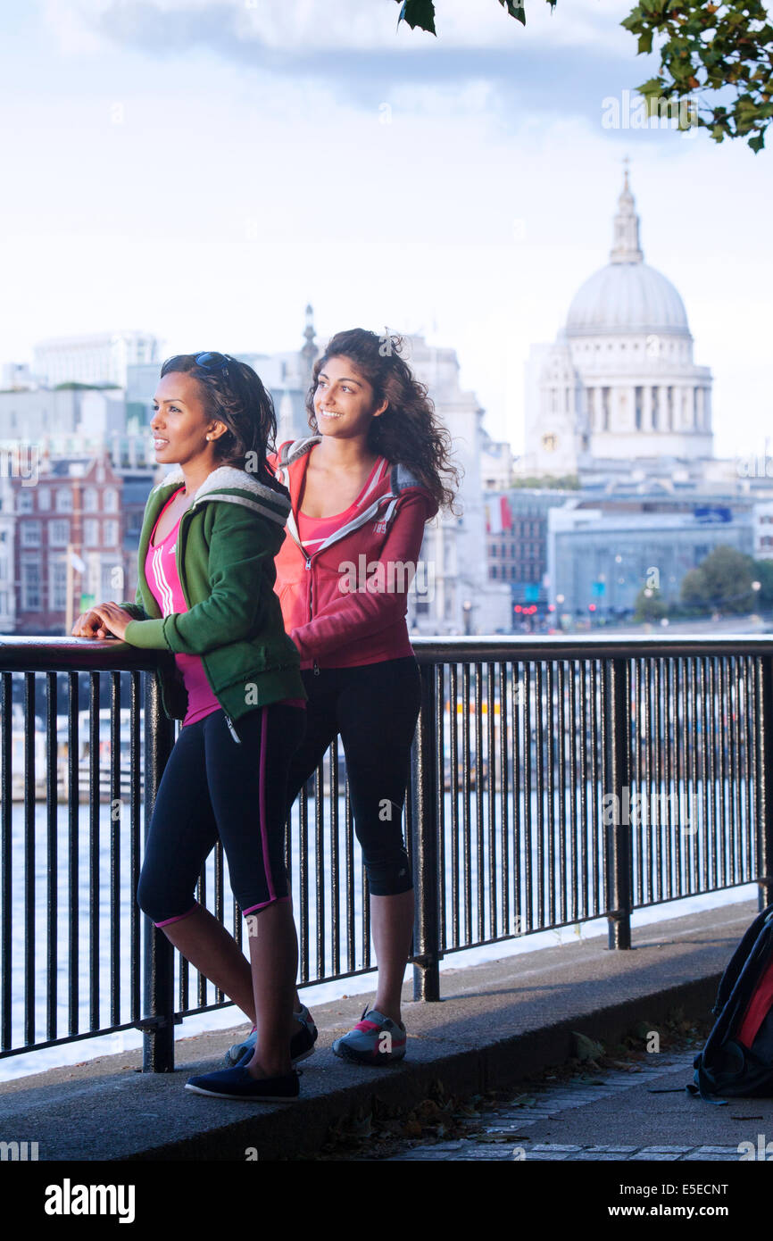 Two young women leaning against a railing on the South Bank of the ...