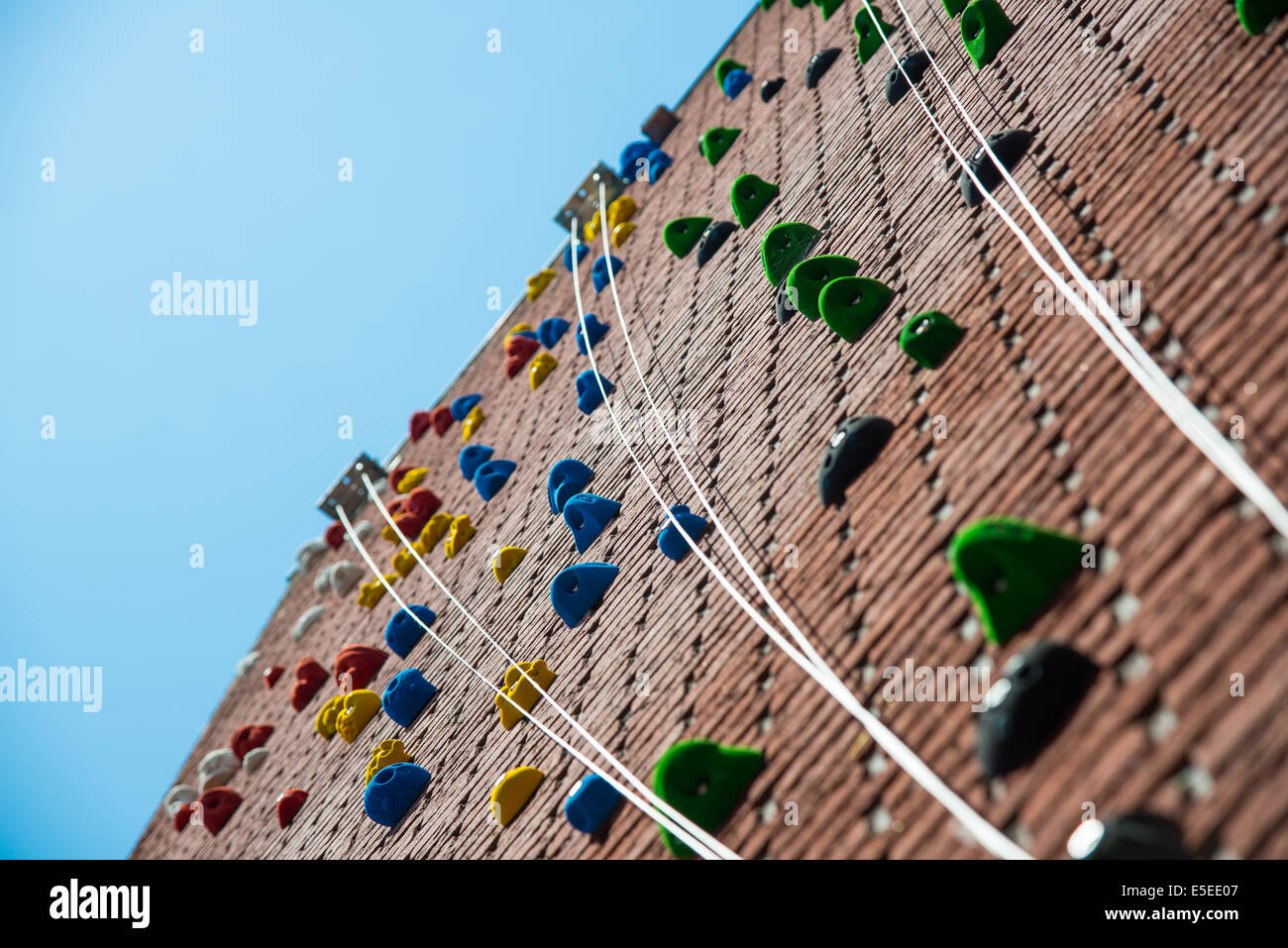 a climbing wall with ropes and blue sky Stock Photo - Alamy