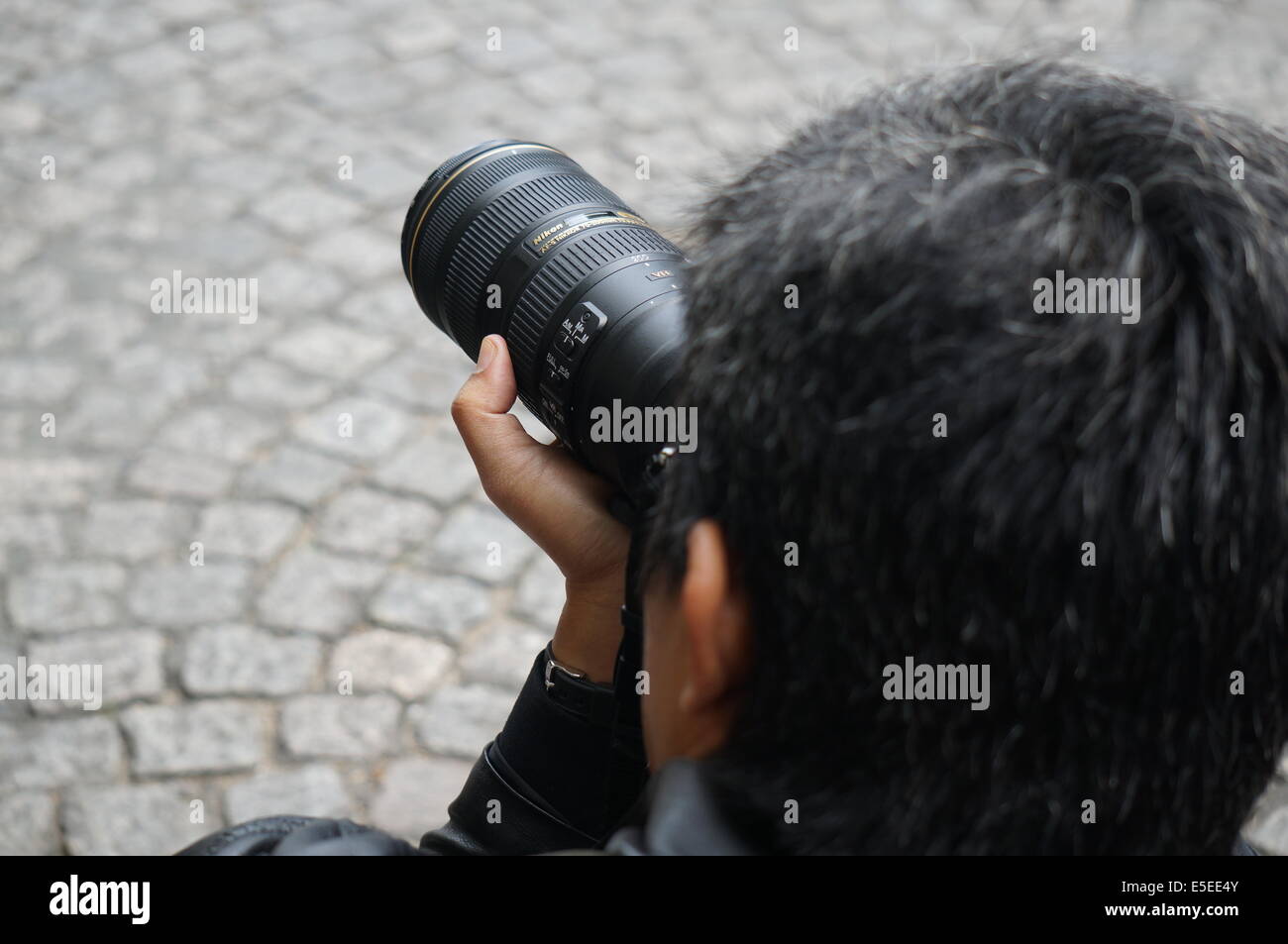 Rear view of a photographer holding a Nikon camera Stock Photo - Alamy