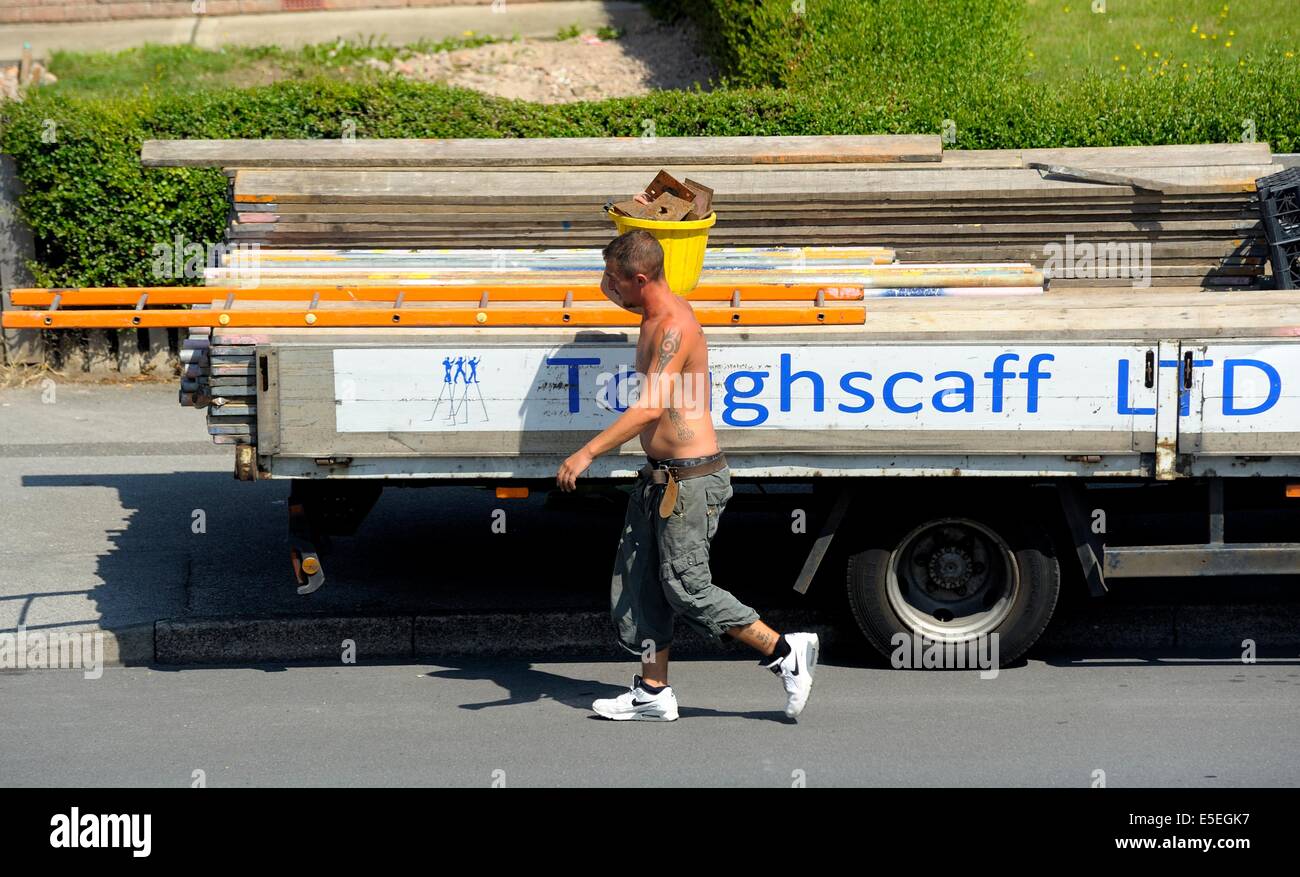 one man carrying a bucket of equipment to erect scaffolding England uk ...