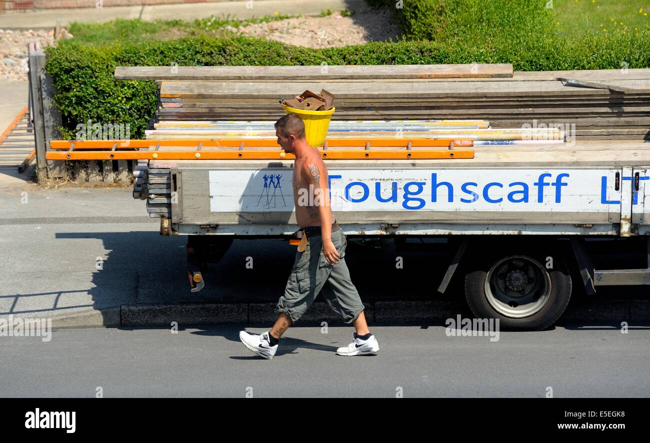 one man carrying a bucket of equipment to erect scaffolding England uk ...