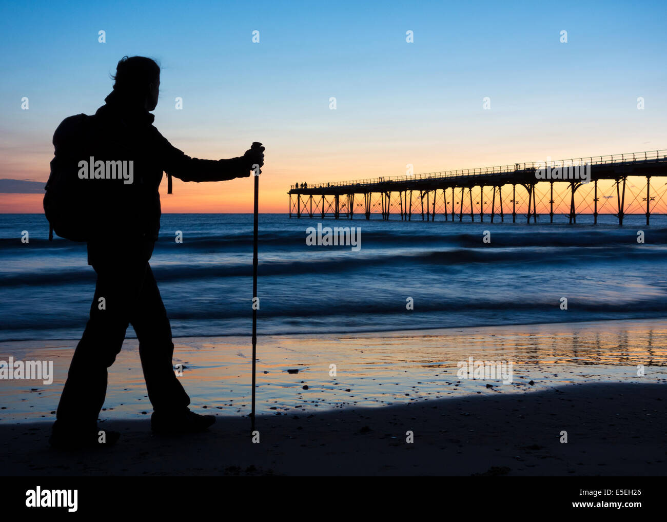 Female walker at sunrise on The Cleveland Way coastal path at Saltburn ...