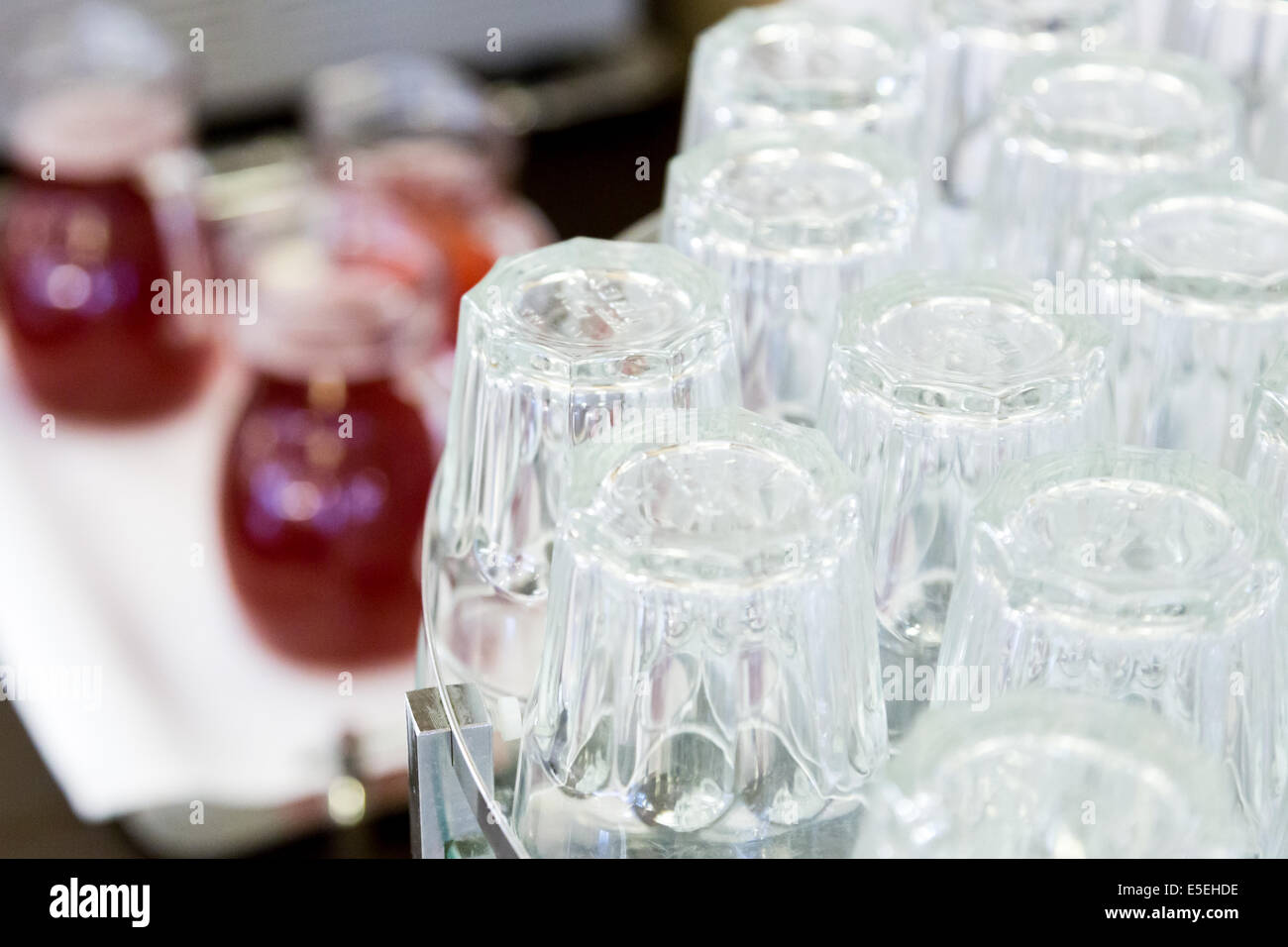 upside-down glasses on counter with gugs of red drink Stock Photo - Alamy