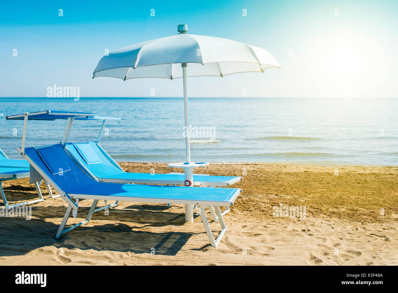 Blue sunbeds and umbrellas on the beach Stock Photo - Alamy