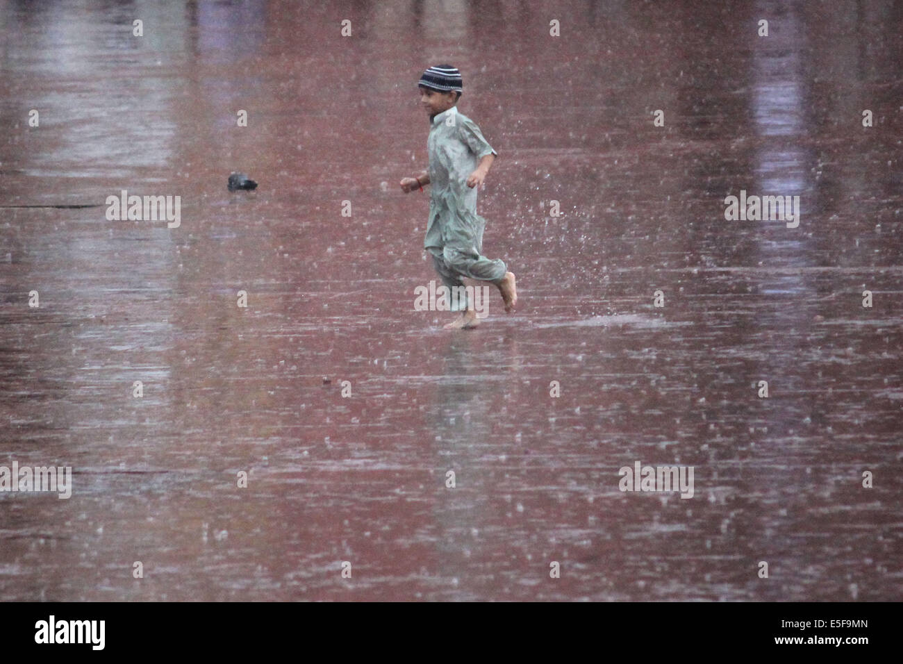 Pakistani Muslim child enjoys the rain after offering the Eid al Fitr ...