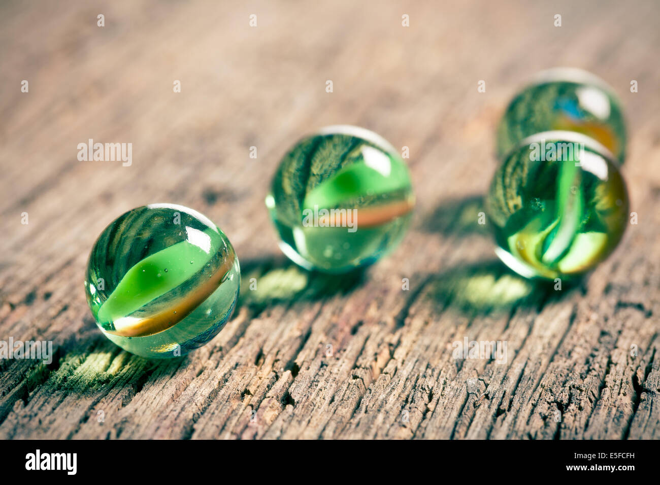 Glass marble balls on old wooden background Stock Photo - Alamy