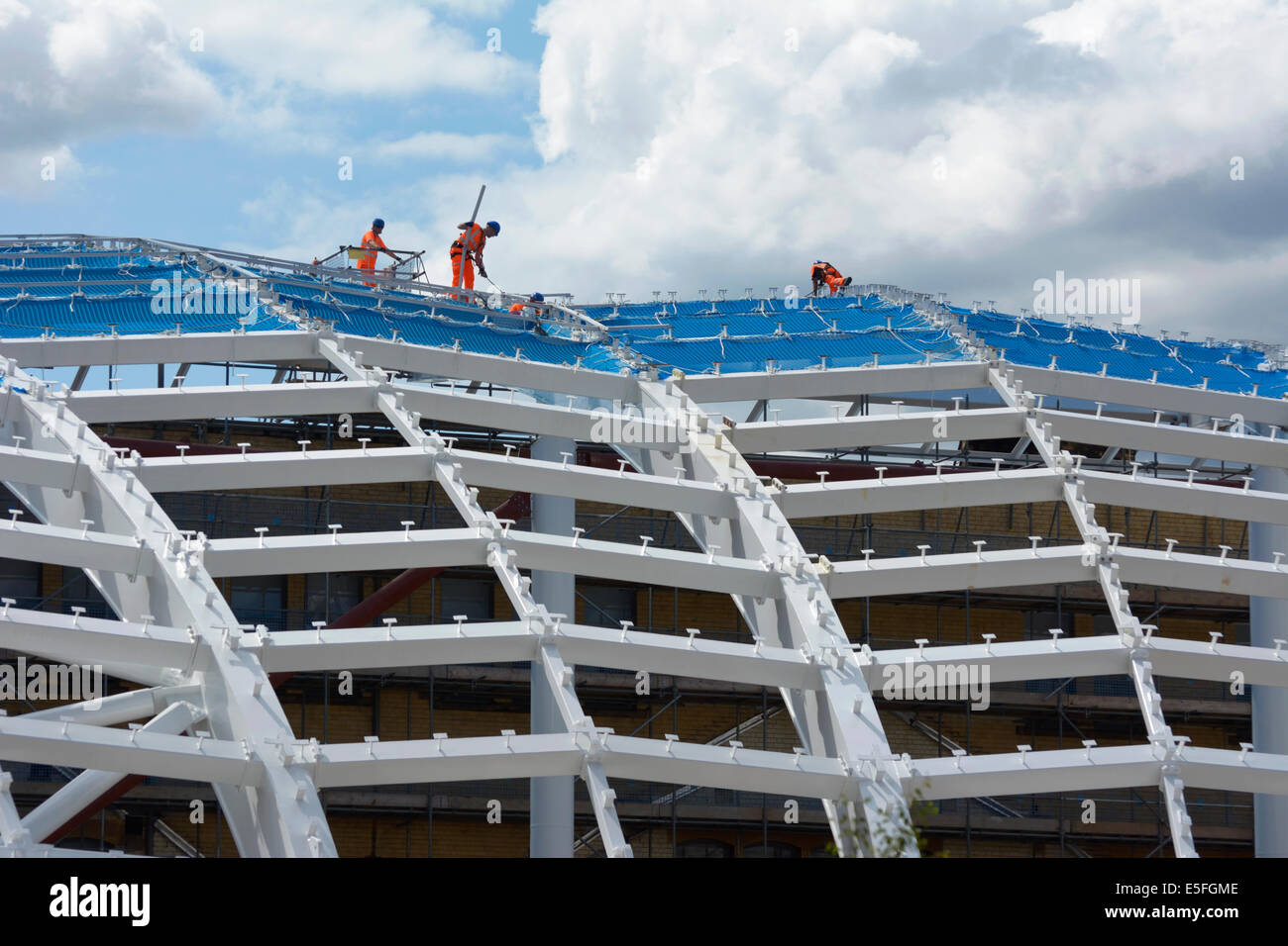 Construction workers on the roof skeleton of the new extension to ...