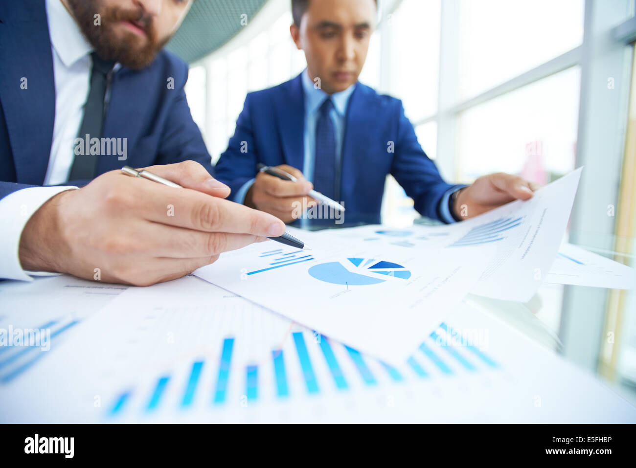 Image of businessman pointing at paper during discussion with his ...