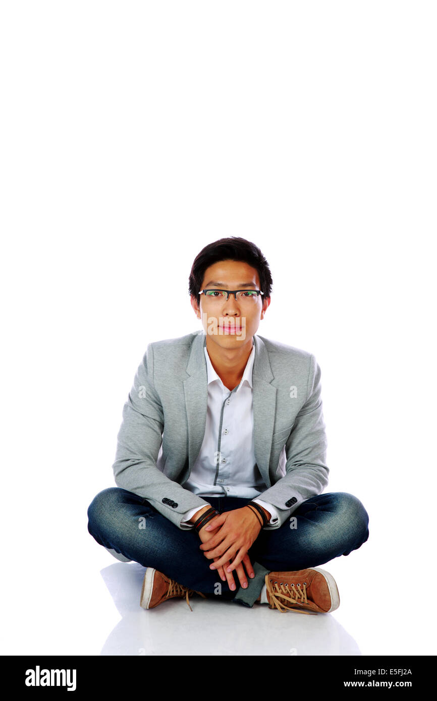 Handsome asian man sitting on the floor over white background Stock ...