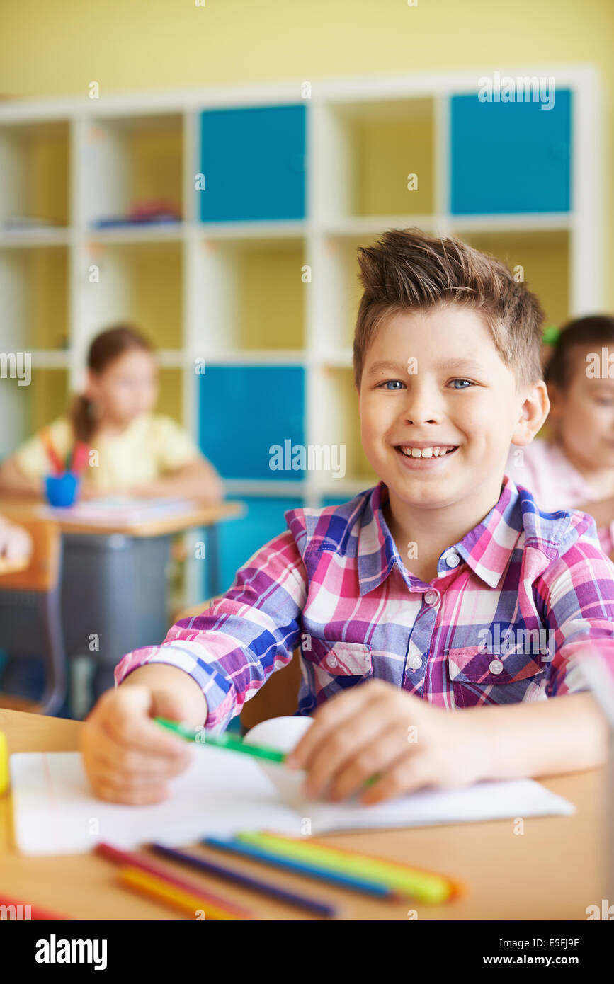 Portrait of a cute schoolboy looking at camera on background of his ...