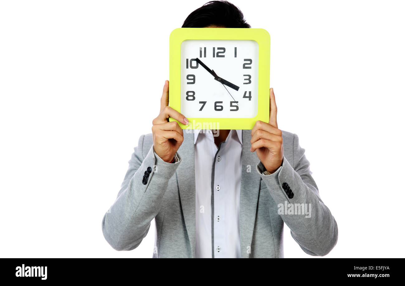 Young man holding clock covering his face over white background Stock ...