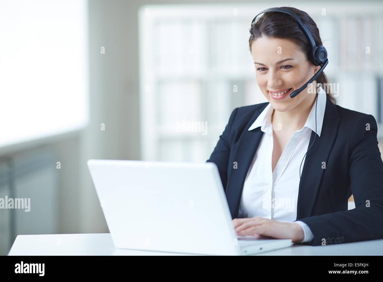 Young customer support representative consulting client on-line while ...