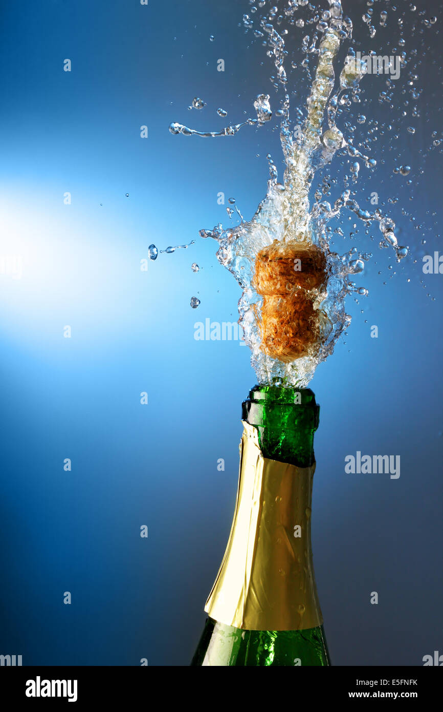 Bottle of champagne with splashes over blue background Stock Photo - Alamy Bottle of champagne with splashes over blue background Stock Photo - Alamy