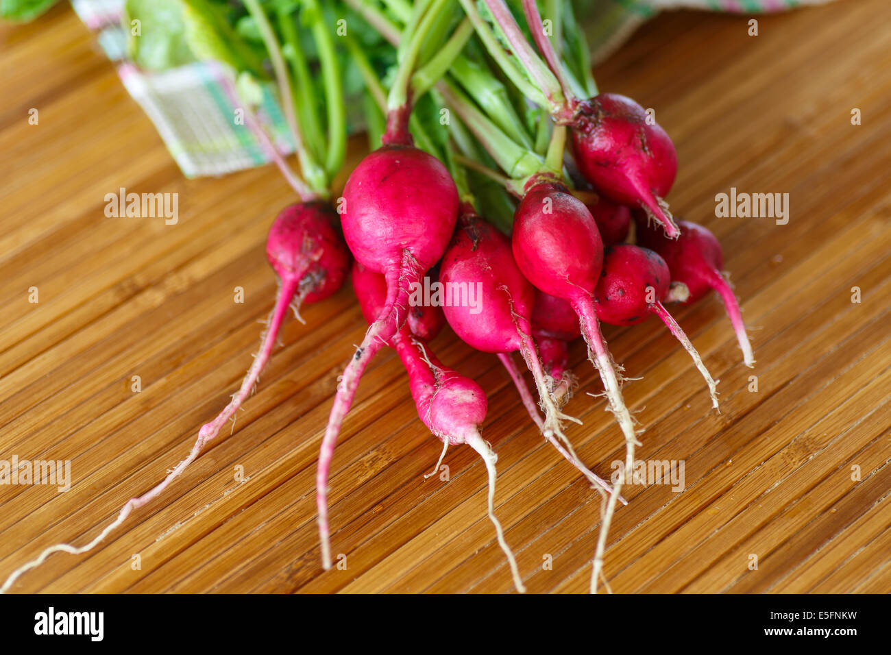 Bunch of fresh radishes on wooden table Stock Photo - Alamy