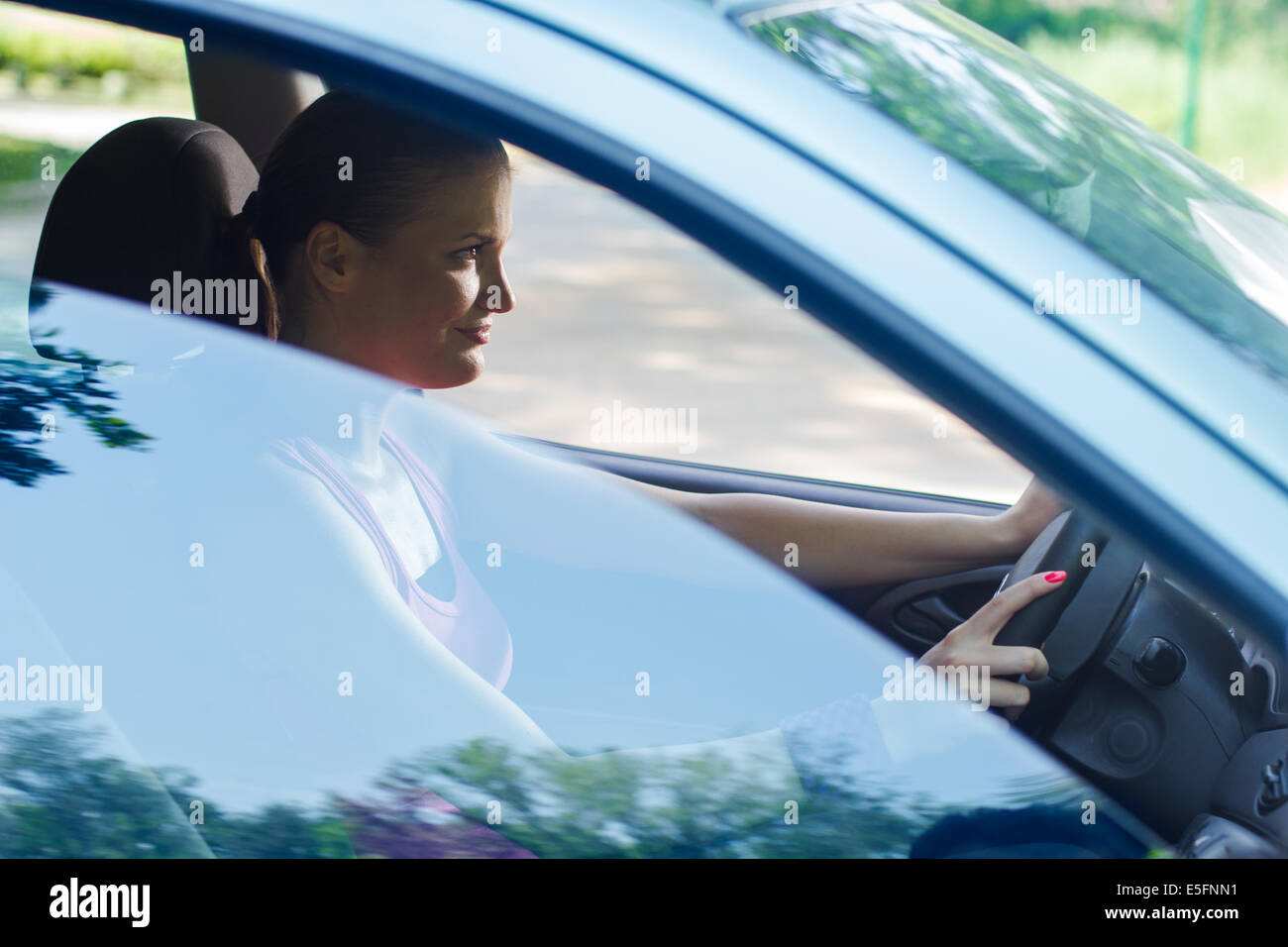 Happy young woman driving a car Stock Photo - Alamy