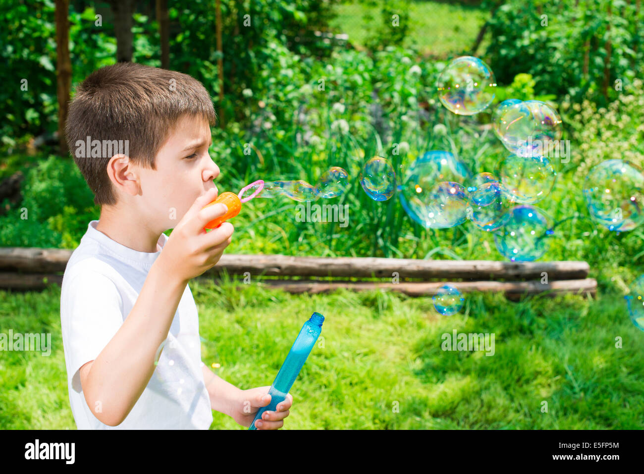Child makes bubbles. Green park Stock Photo - Alamy