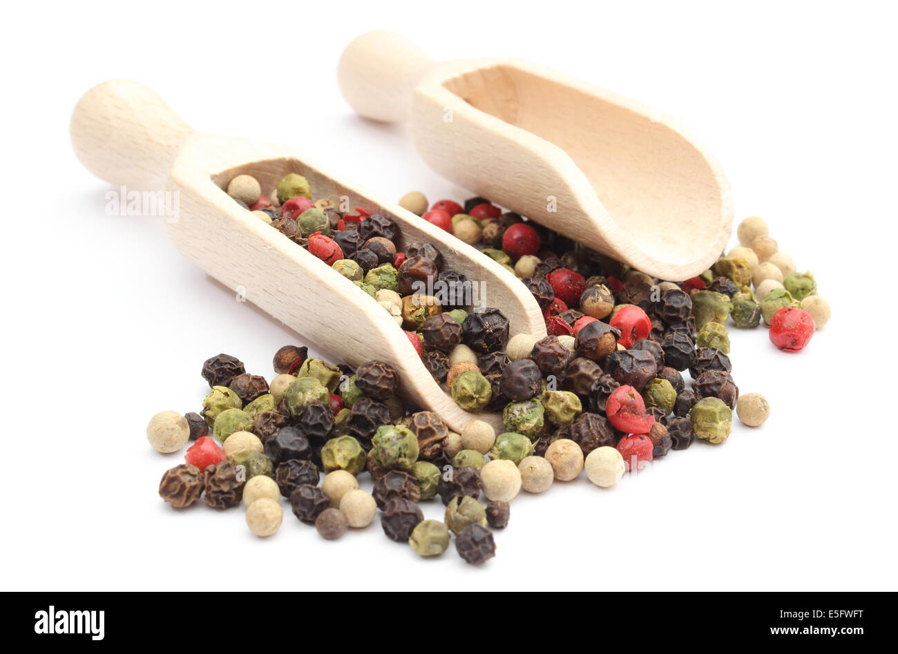 Fresh pepper on wooden spoon lying on stack of colored pepper. Isolated ...