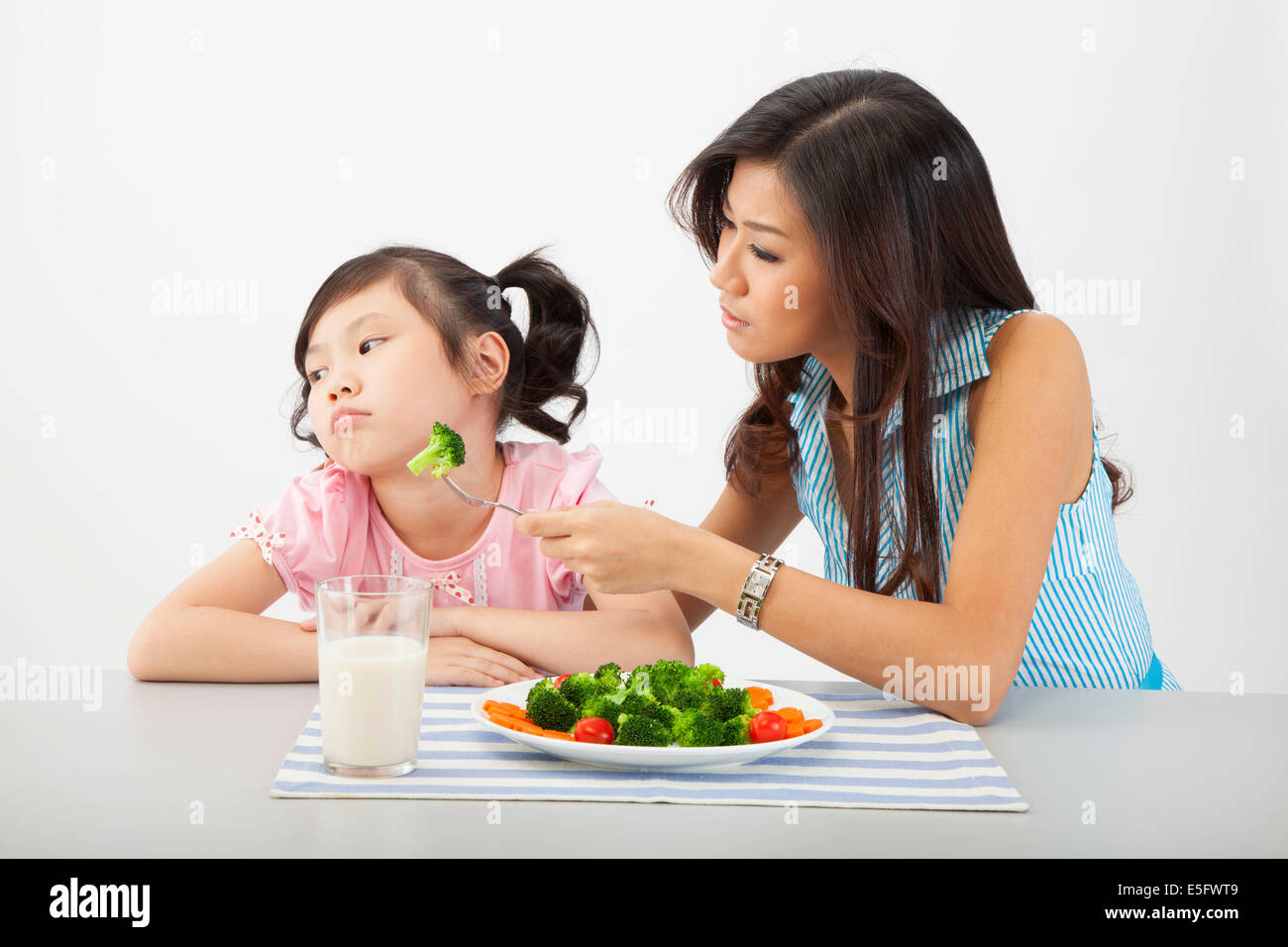 Asian chinese young mother feeding daughter with no appetite Stock ... Asian chinese young mother feeding daughter with no appetite Stock ...