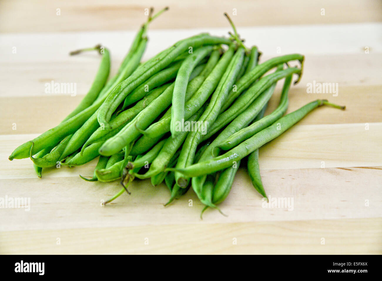 Green beans on a light wood table Stock Photo - Alamy
