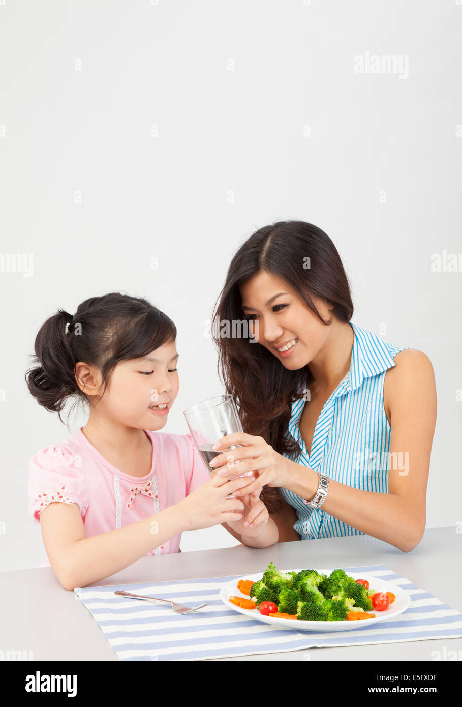 Young asian chinese mother helping her daughter to drink water Stock ... Young asian chinese mother helping her daughter to drink water Stock ...