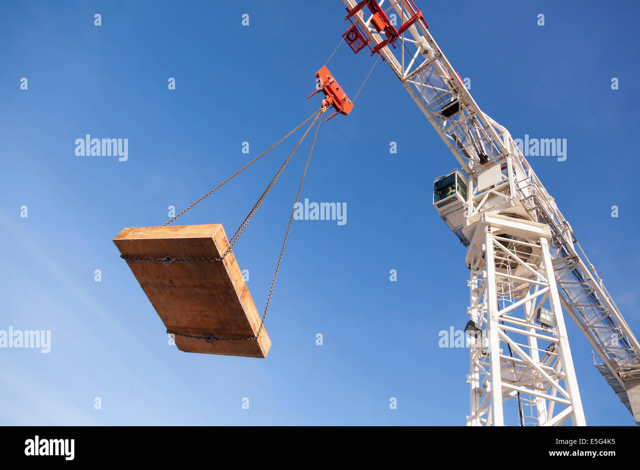 A crane lifting a wooden box at a rooftop construction site in Toronto ...