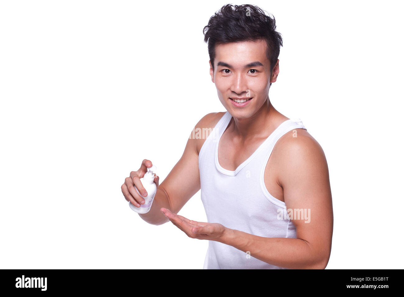 Young man holding skin care product Stock Photo - Alamy