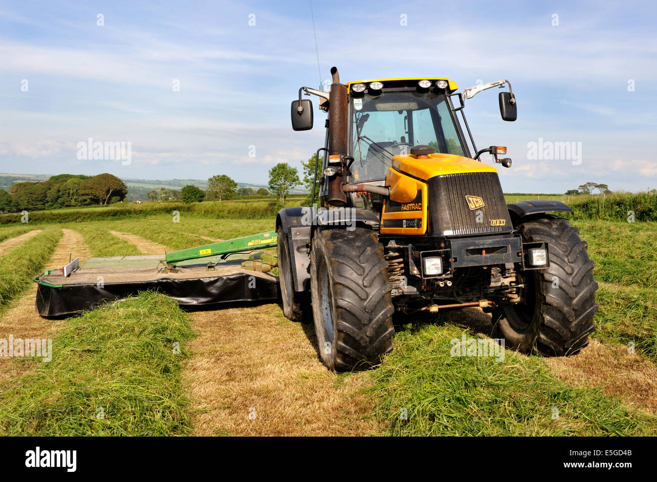 Agricultural field with hay racked to aid drying with tractor equipped ...