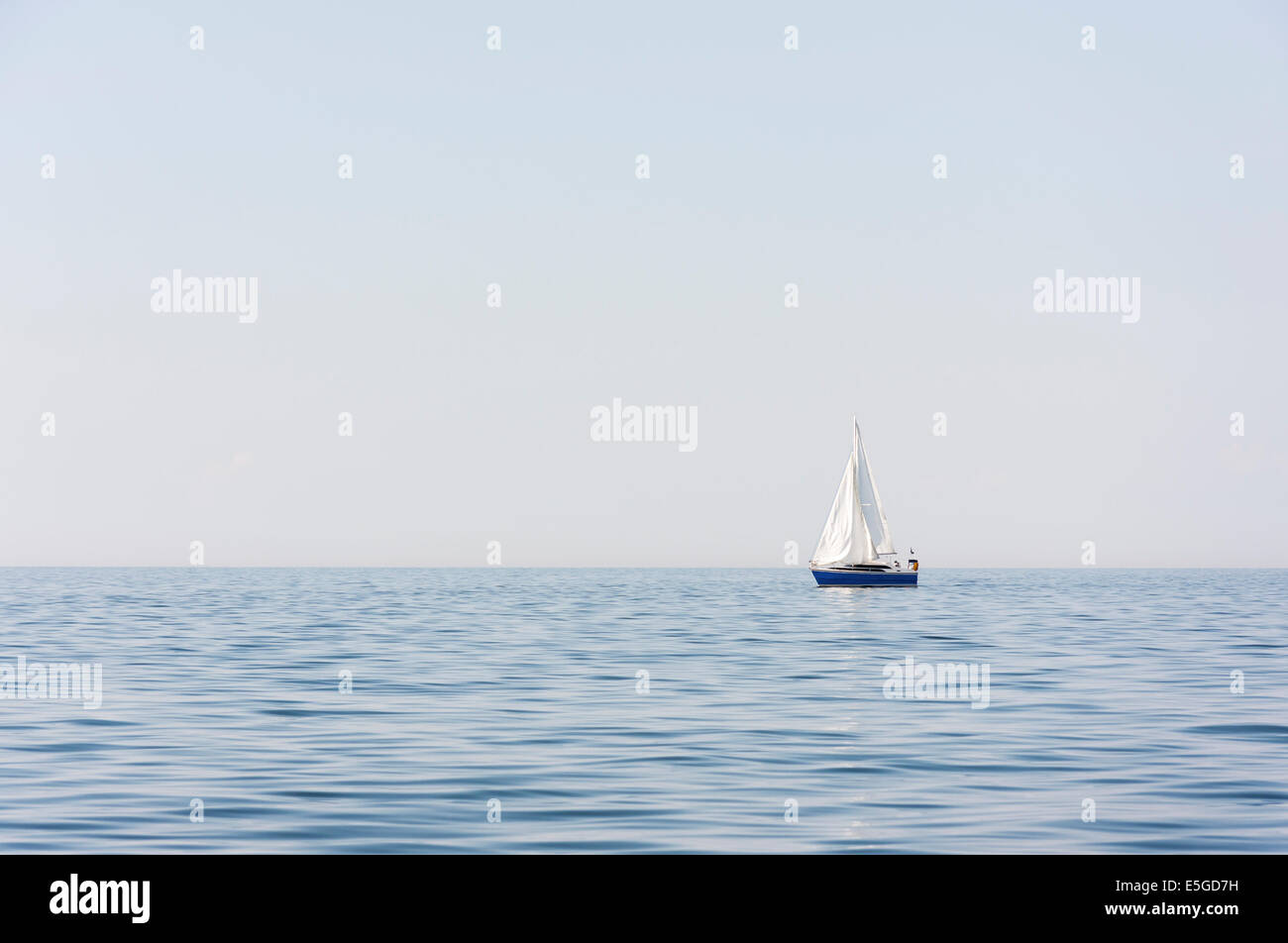 Blue sail ship with white sails at sea or ocean Stock Photo - Alamy