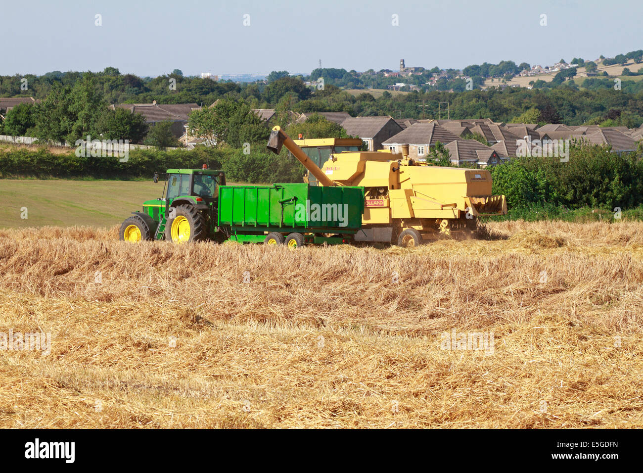 Combine harvester and tractor in a crop field, Honley, Holmfirth, West ...