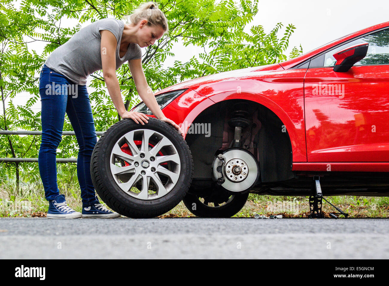 A young woman will change a wheel on a car. Photo: picture alliance ...