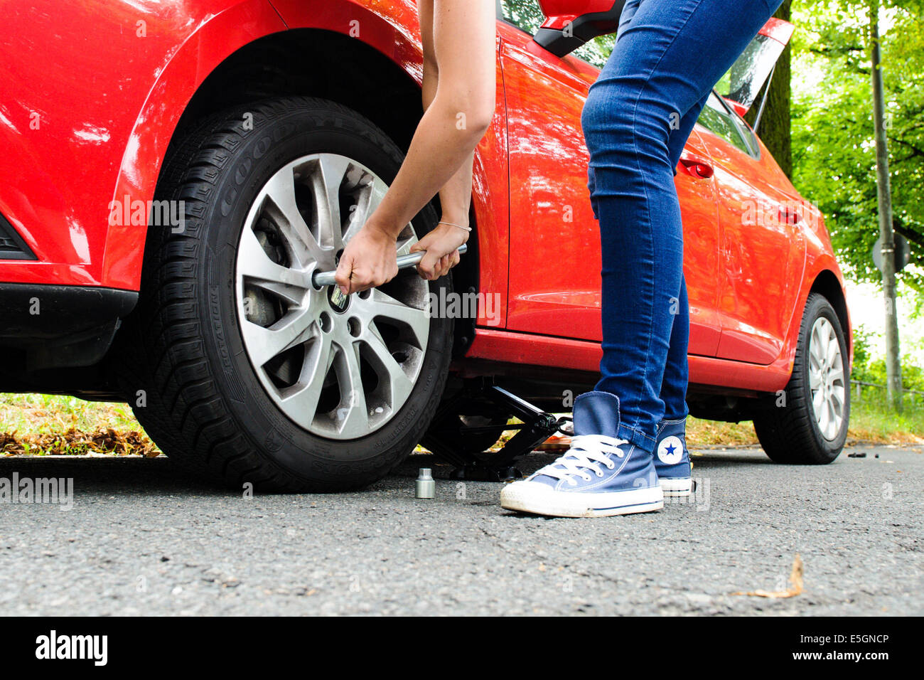 A young woman will change a wheel on a car. Photo: picture alliance ...