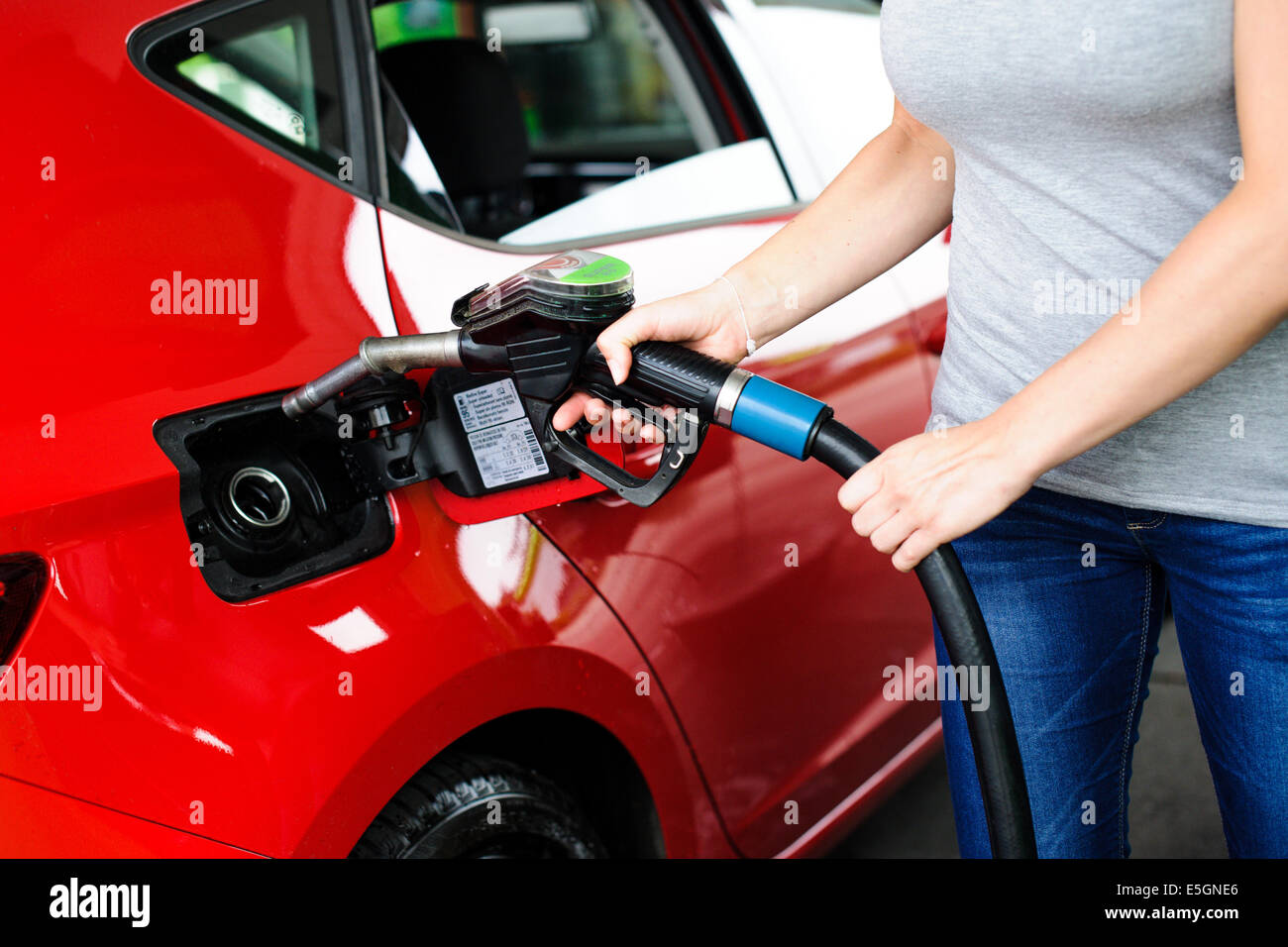 A young woman refueling a car. Photo: picture alliance/Robert ...
