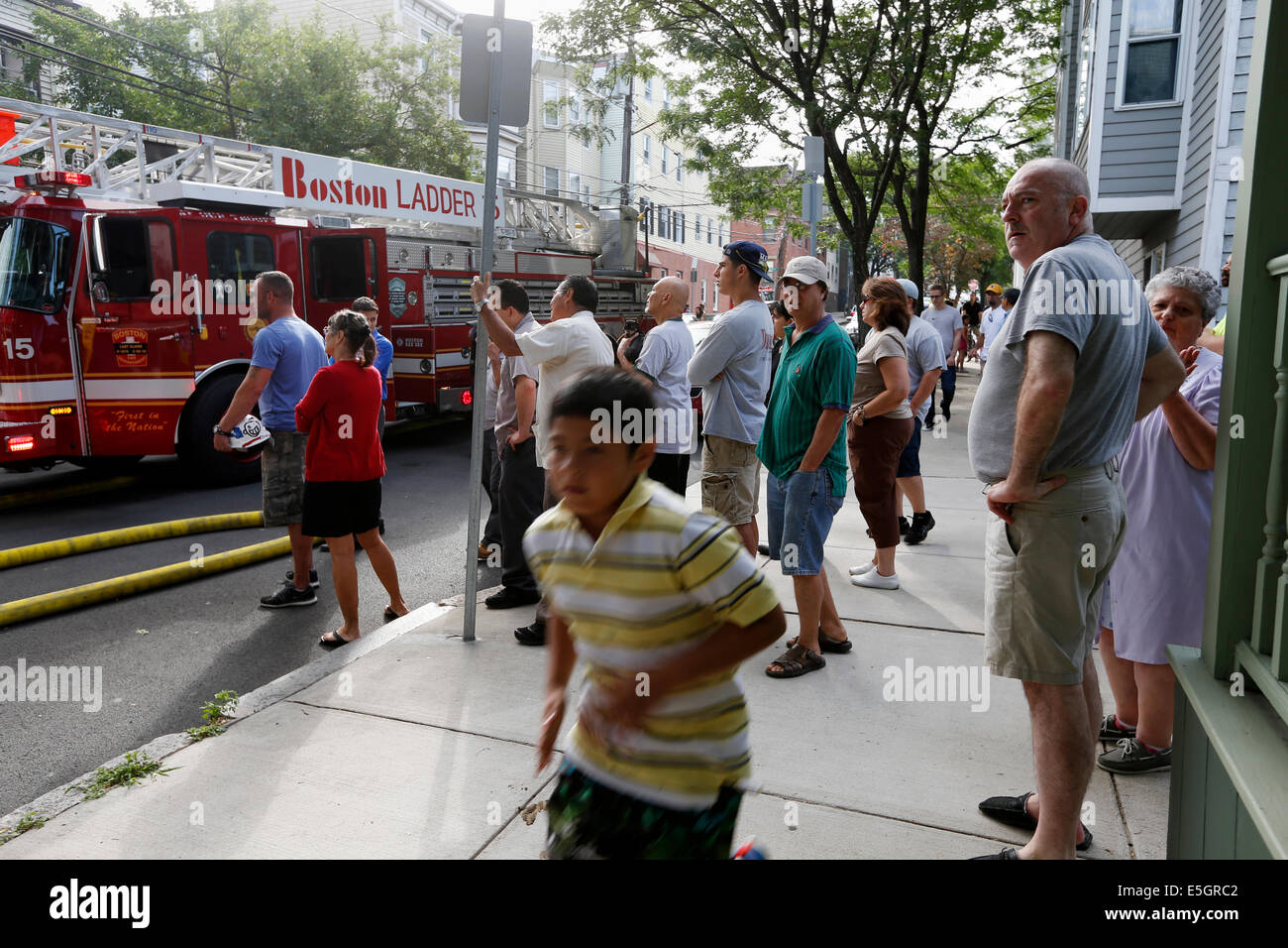 People gather to watch firefighters responding to a 6-alarm house fire ...