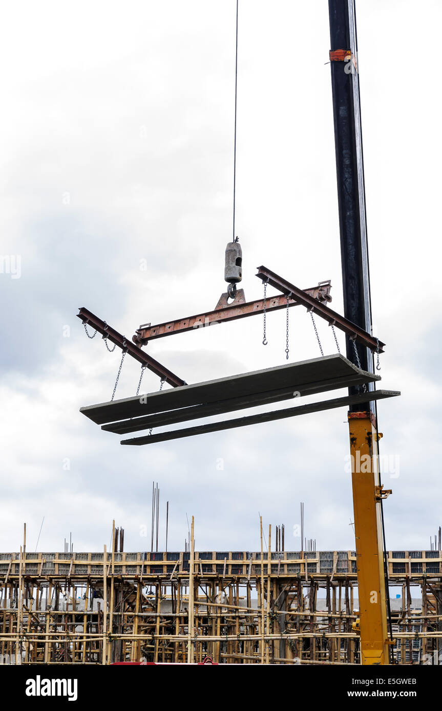 Crane hoist concrete plate at construction site Stock Photo - Alamy