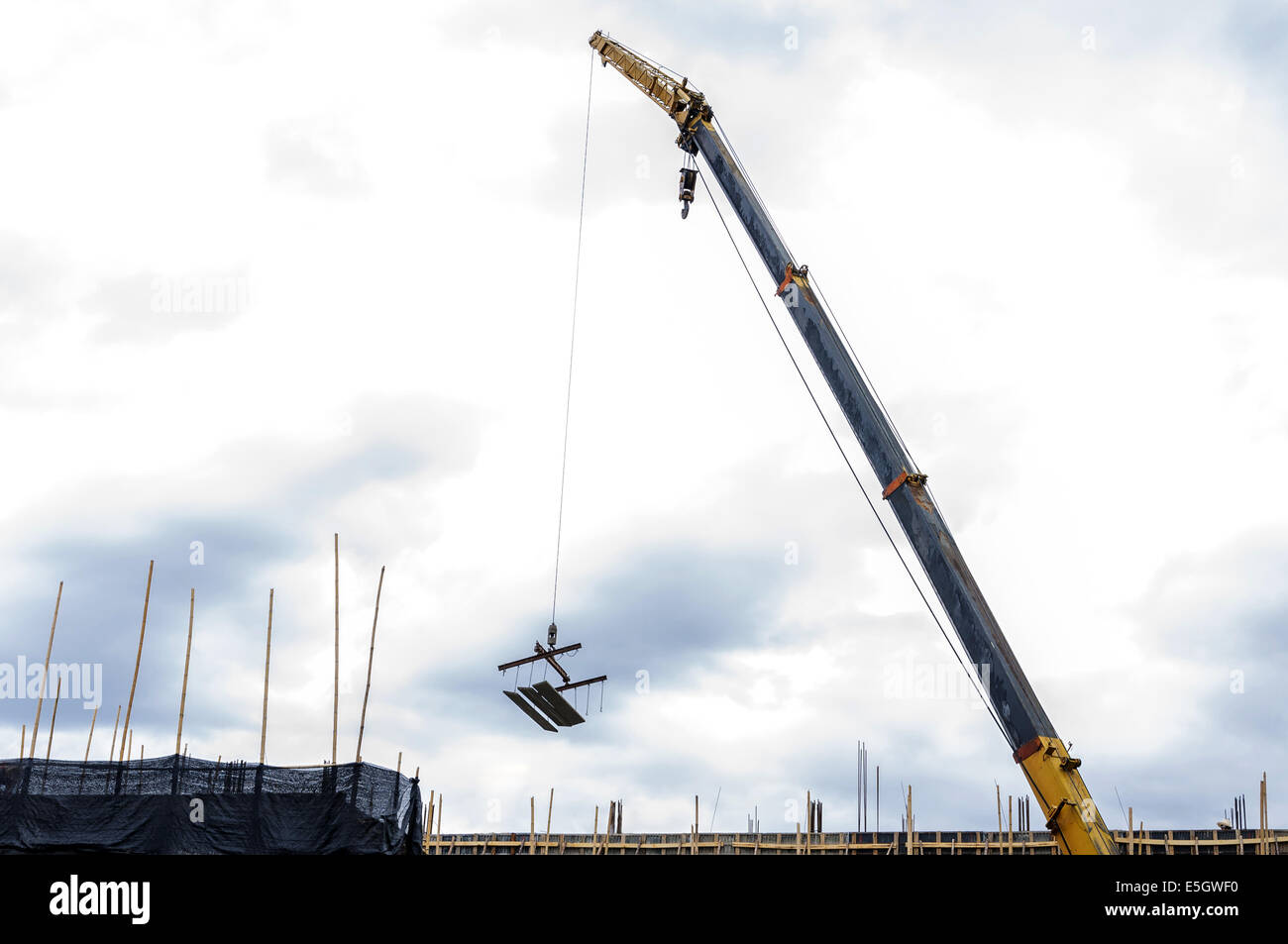 Crane hoist concrete plate at construction site Stock Photo - Alamy