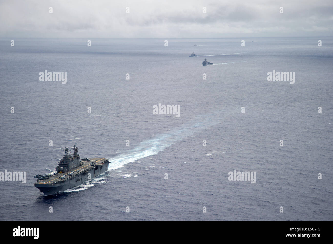 The amphibious assault ship USS Peleliu (LHA 5), foreground, steadies ...